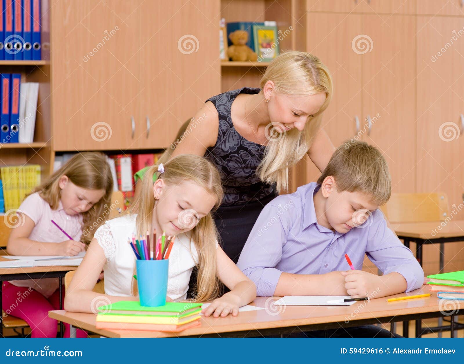 Young Teacher Helps Students of Primary School in the Exam Stock Photo ...