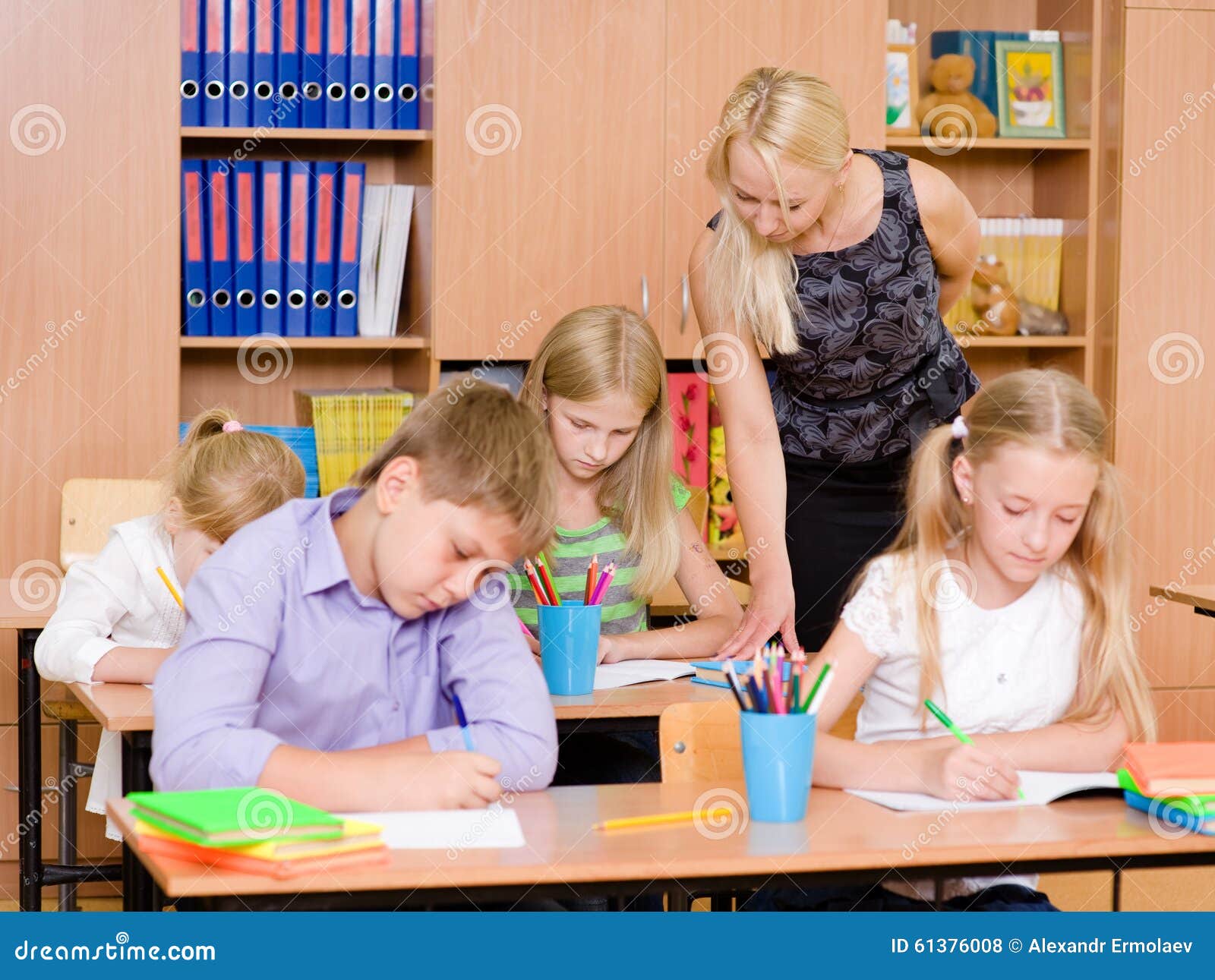Young Teacher Helps Students of Primary School in the Exam Stock Photo ...