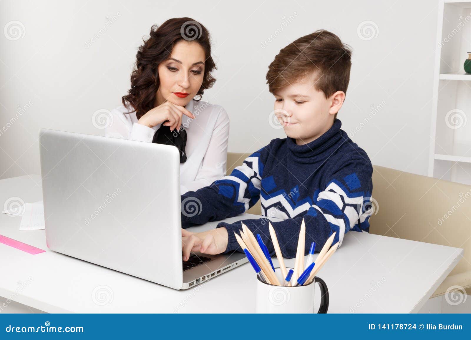 Young Teacher with Kid Doing Homework on a Computer. Tutor Help. Stock ...
