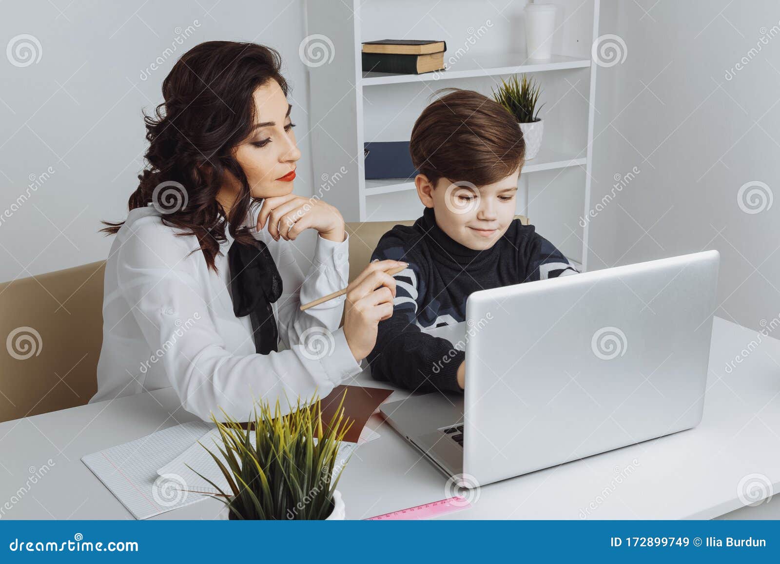 Young Teacher with Kid Doing Homework on a Computer. Tutor Help. Stock ...