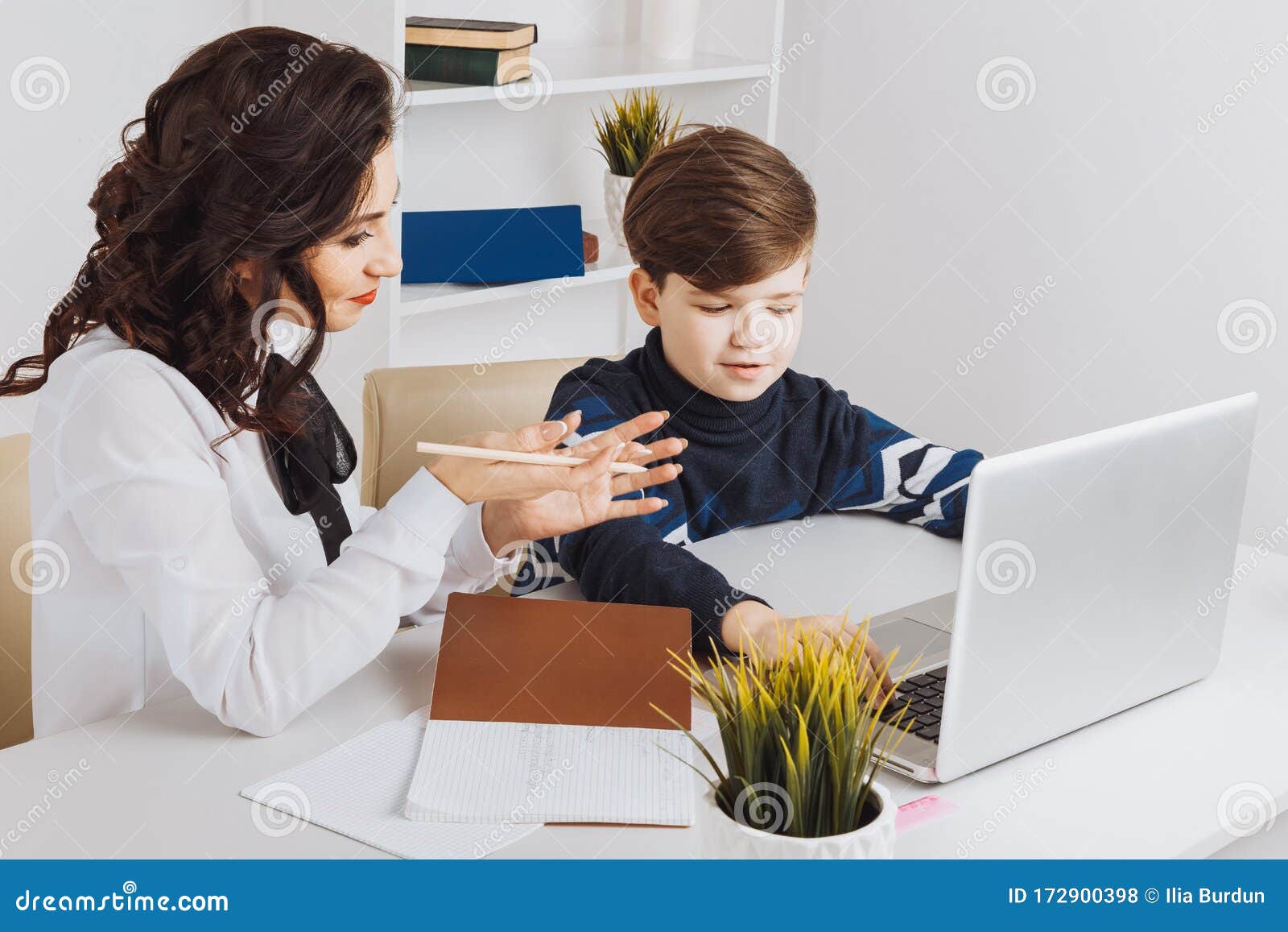 Young Teacher with Kid Doing Homework on a Computer. Tutor Help. Stock ...