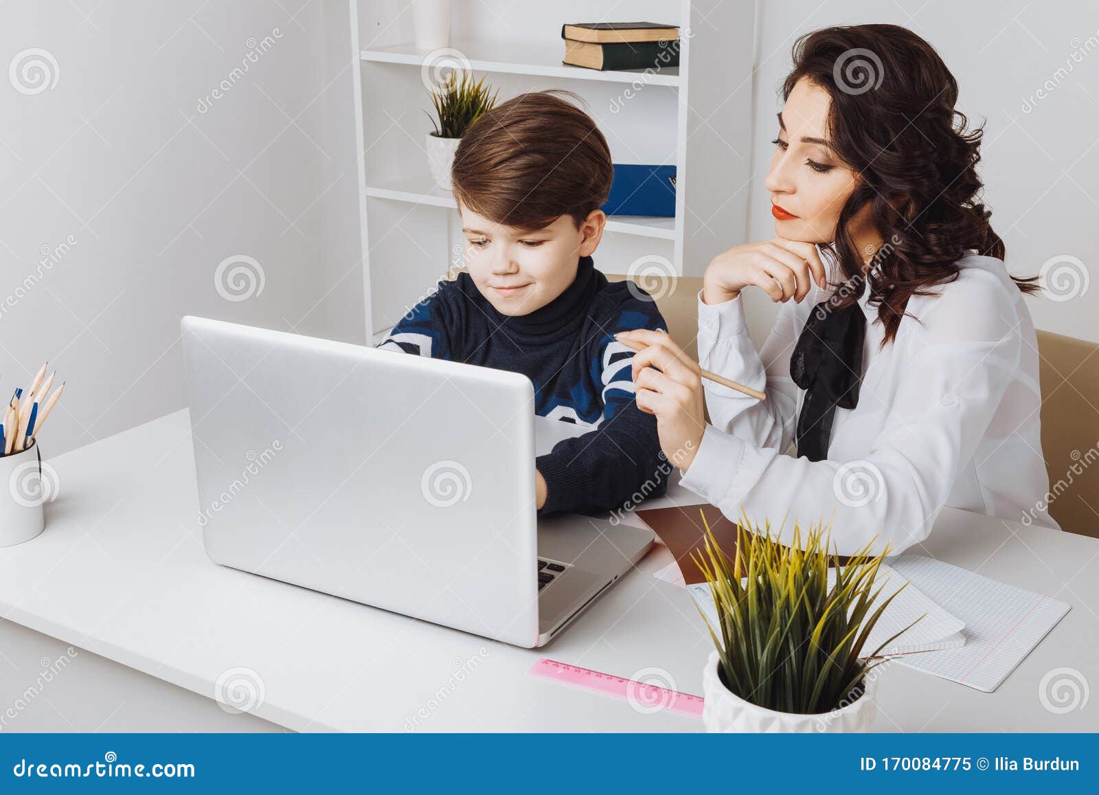 Young Teacher with Kid Doing Homework on a Computer. Tutor Help. Stock ...