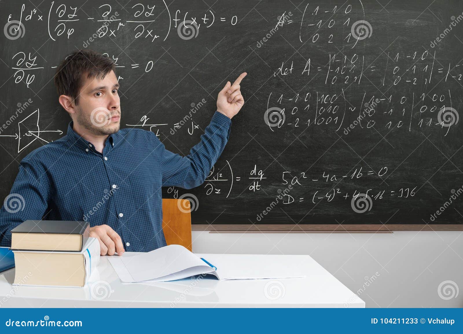Young Teacher is Pointing on Math Formulas on Blackboard with Finger ...