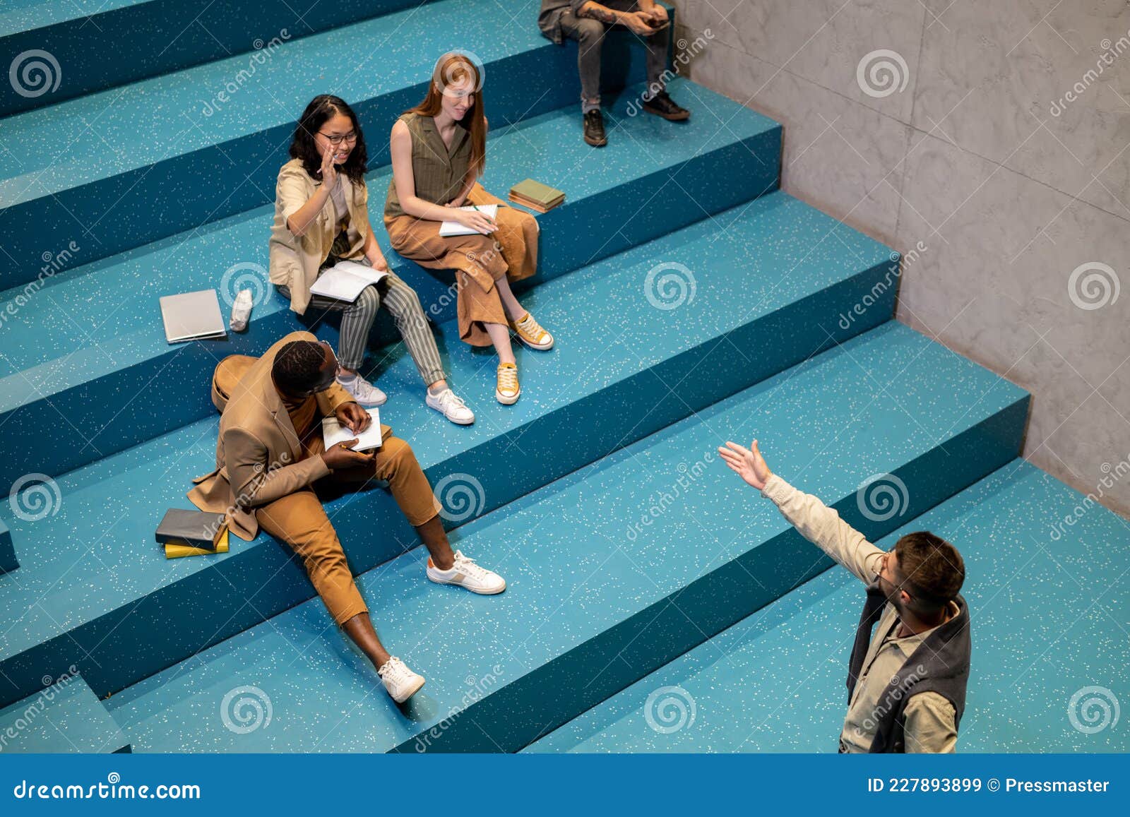 Young Teacher Pointing at Student with Raised Hand Stock Image - Image ...
