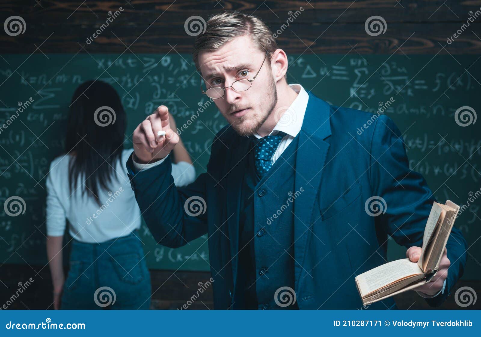 Young Teacher Professor Explaining Mathematic Formula, Giving a Lecture ...