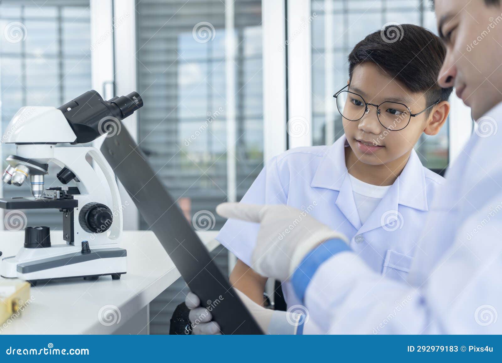Young Teacher and Student Boy Use Microscope in Science Class at ...
