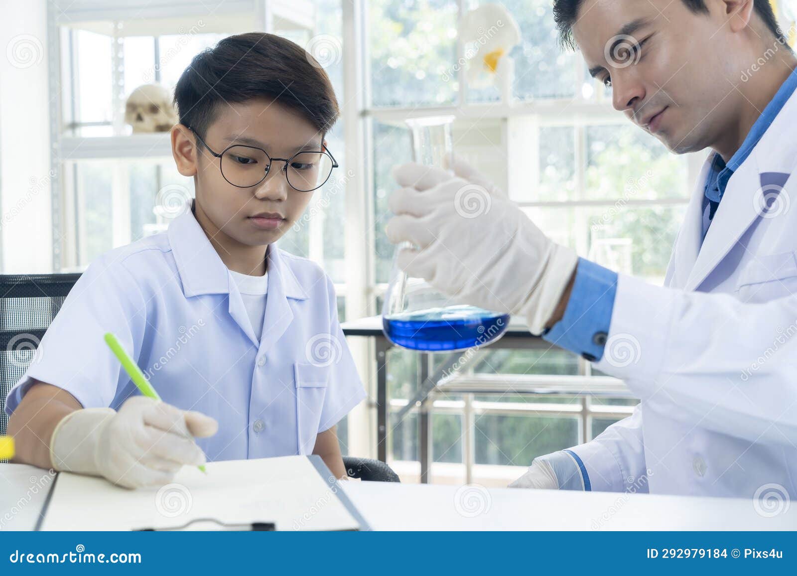 Young Teacher and Student Boy Use Microscope in Science Class at ...