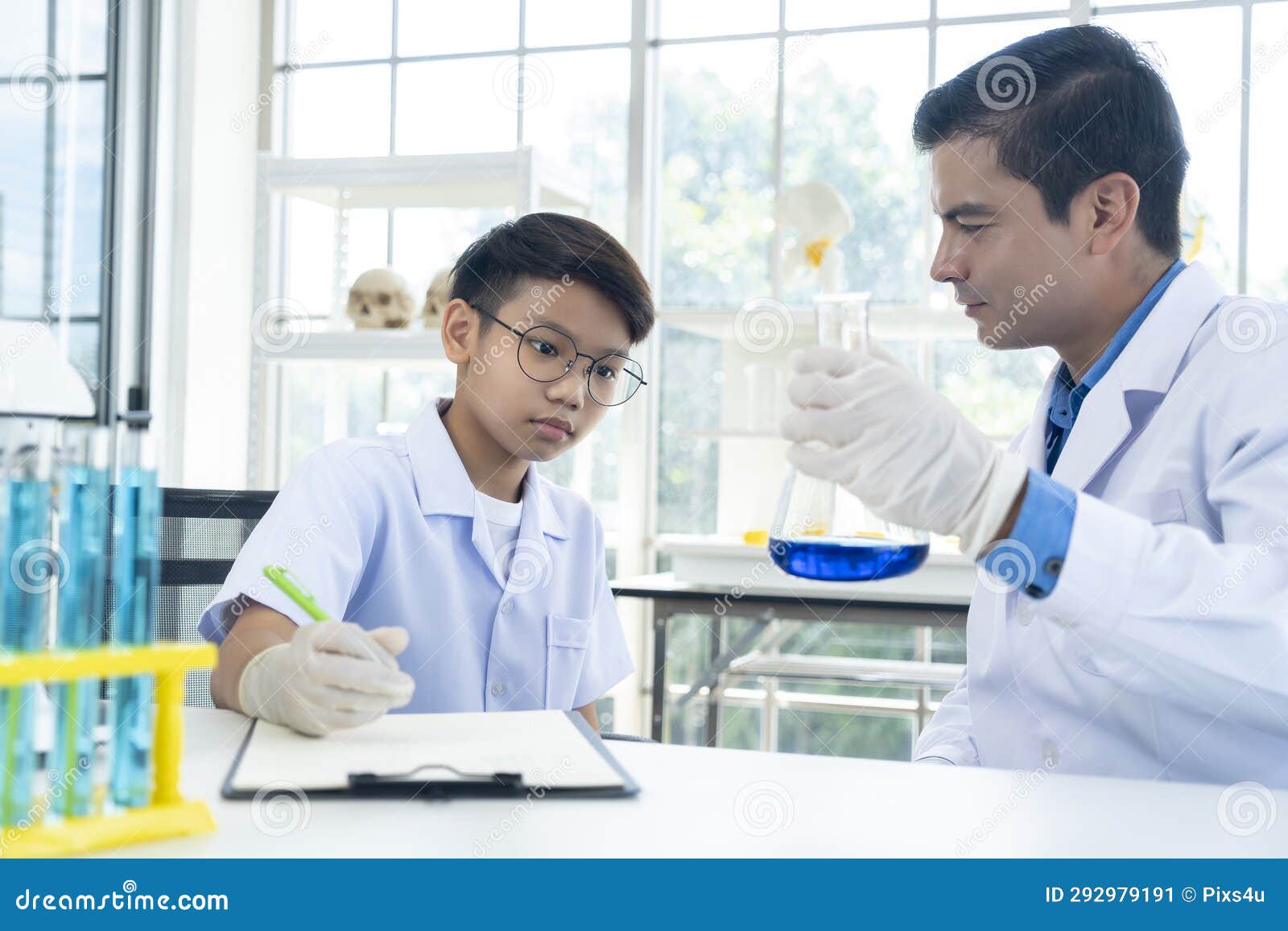 Young Teacher and Student Boy Use Microscope in Science Class at ...