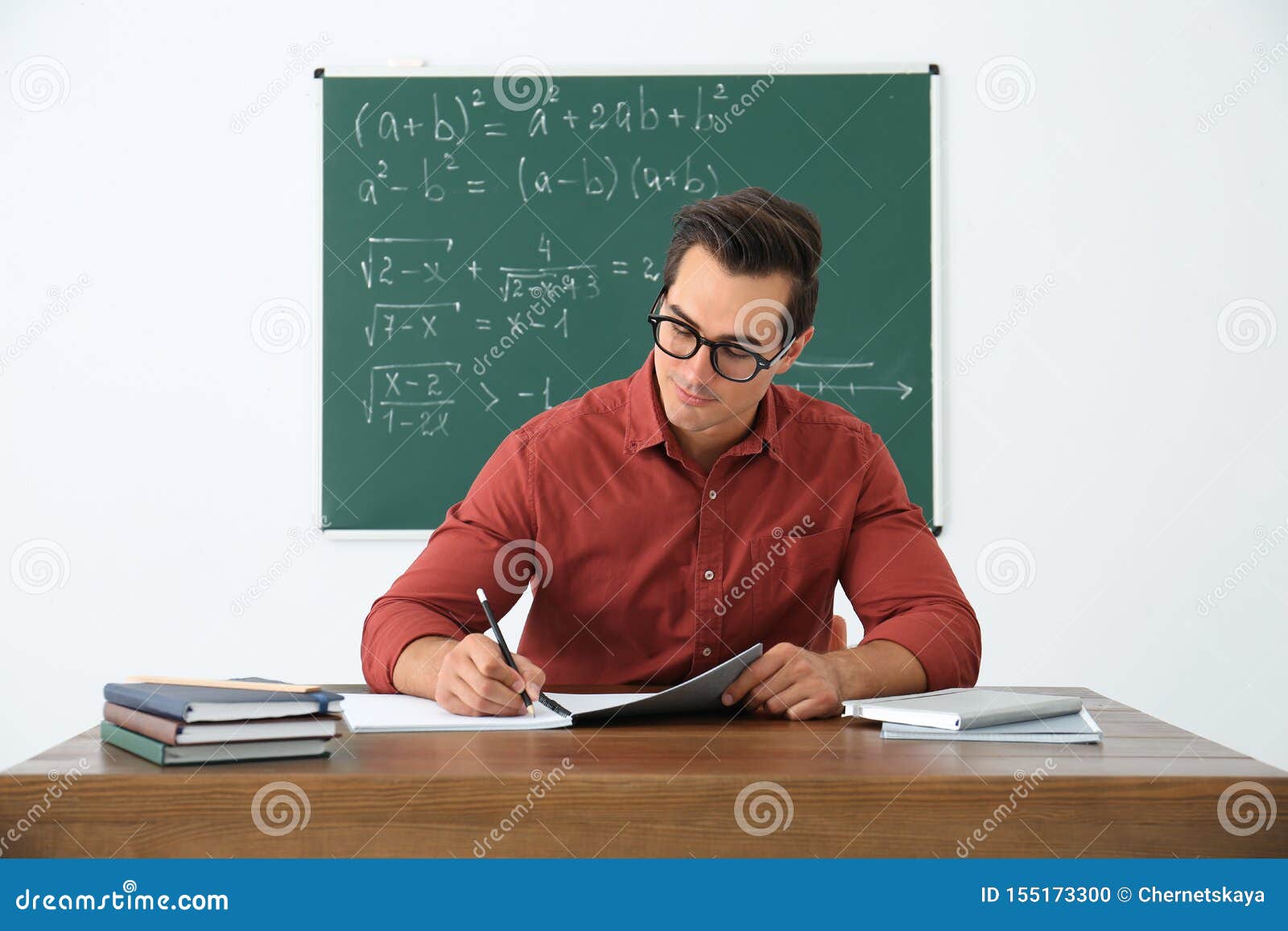 Young Teacher Working at Table in Stock Photo - Image of blackboard ...