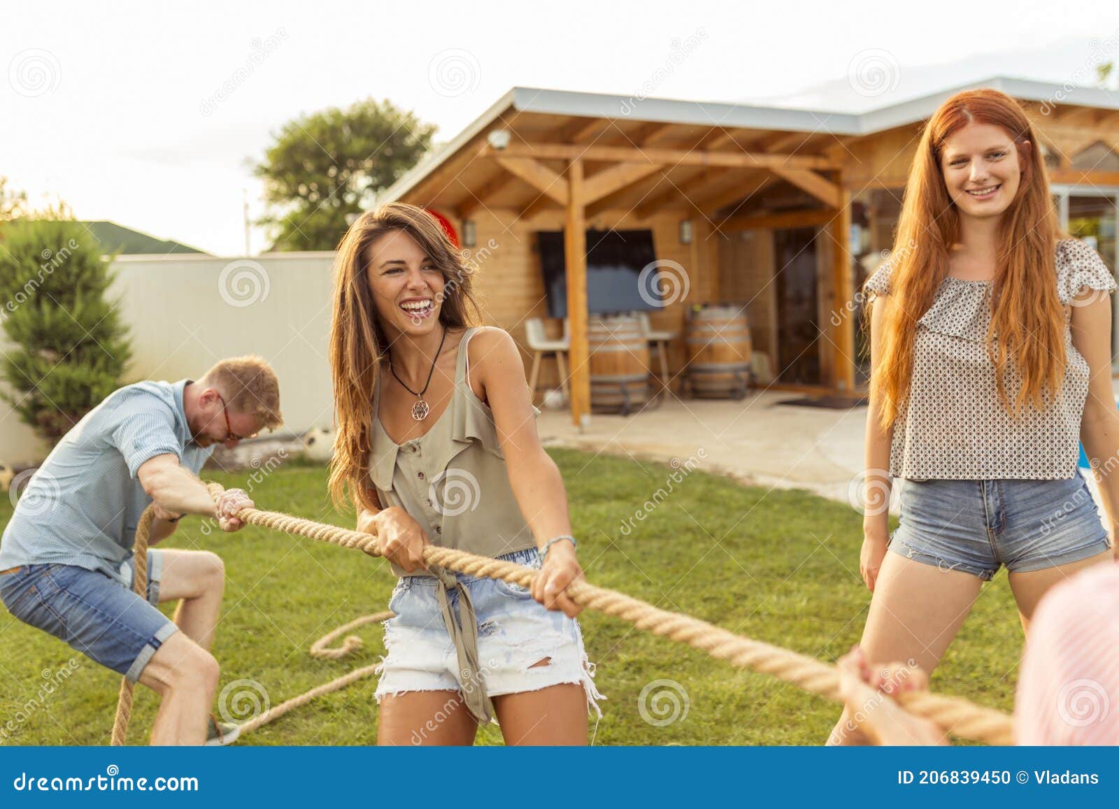 Friends Having Fun while Pulling Rope at an Outdoor Summertime Party ...