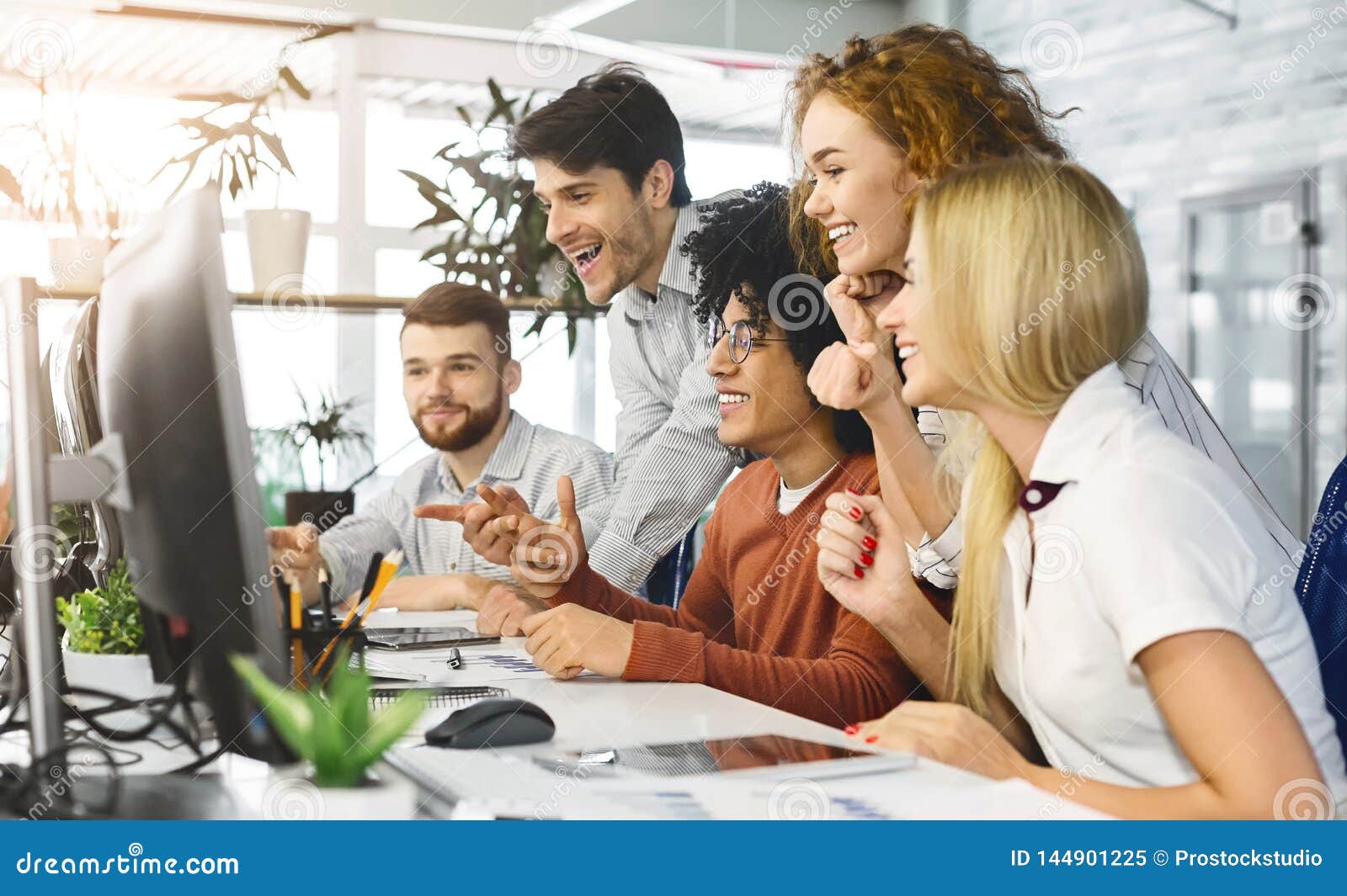Young Team Looking at Computer Screen in Office Together Stock Image ...