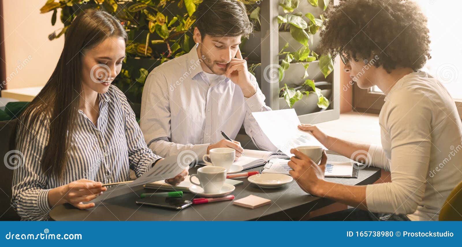 Young Team Reading Documents during Lunch in Cafe Stock Photo - Image ...