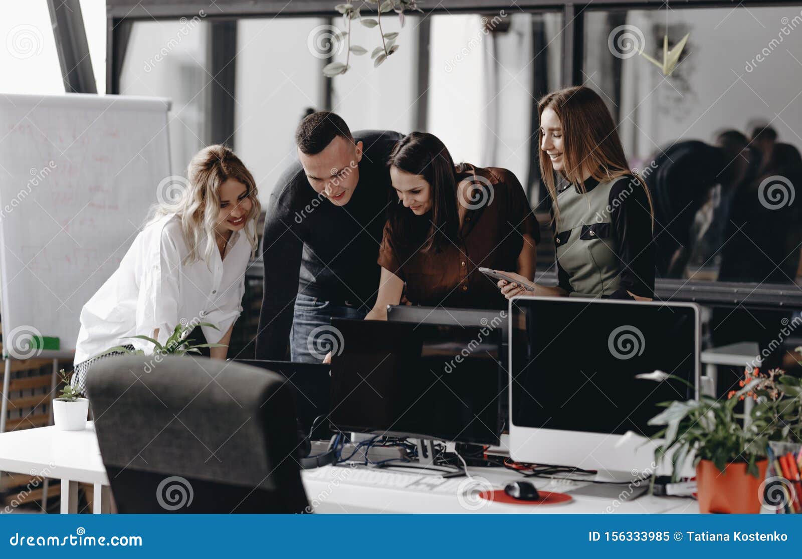 Young Team Works at the Desks with a Computer and Laptops in a Light ...