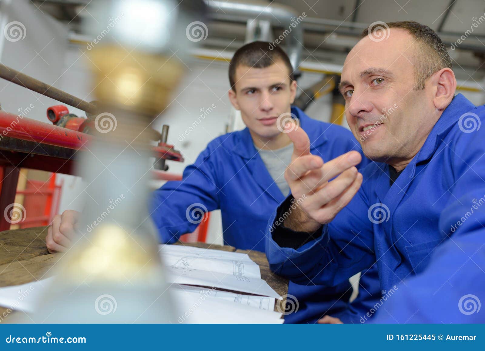 Young Technician Working on Machine in Workshop with Co-worker Stock ...