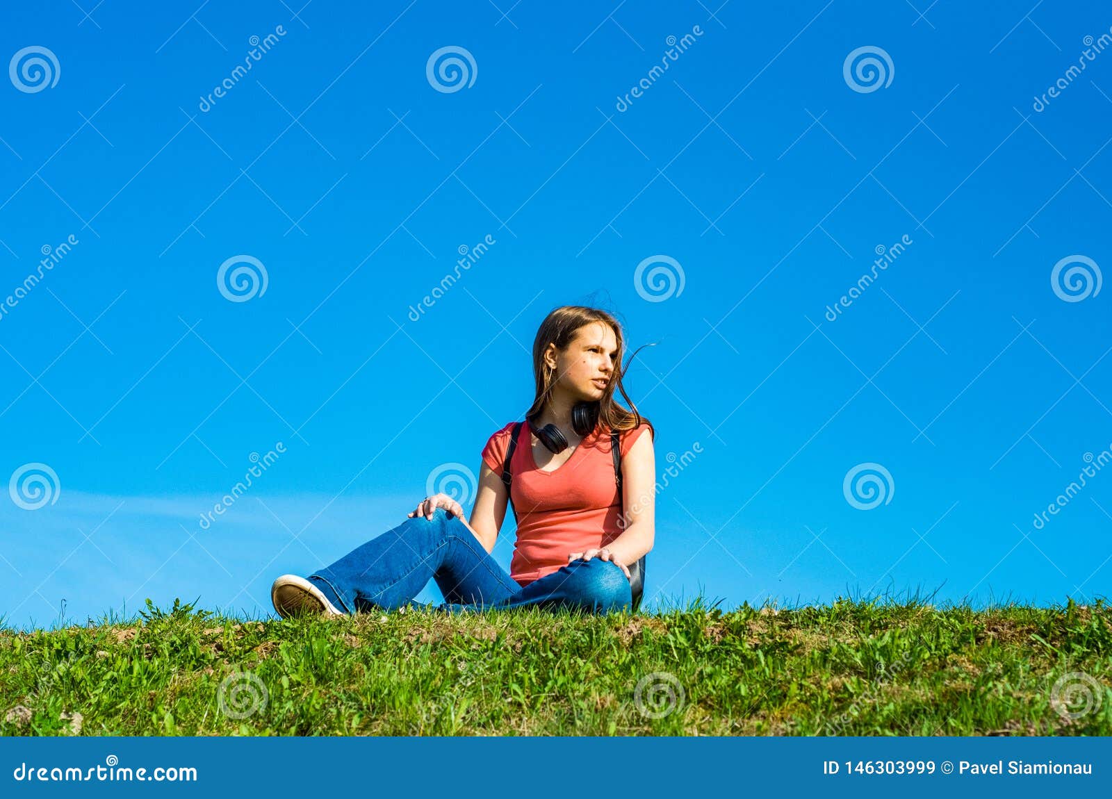 Teenager Brunette Girl in Coral T-shirt with Long Hair Sit on the Grass ... Teenager Brunette Girl in Coral T-shirt with Long Hair Sit on the Grass ...