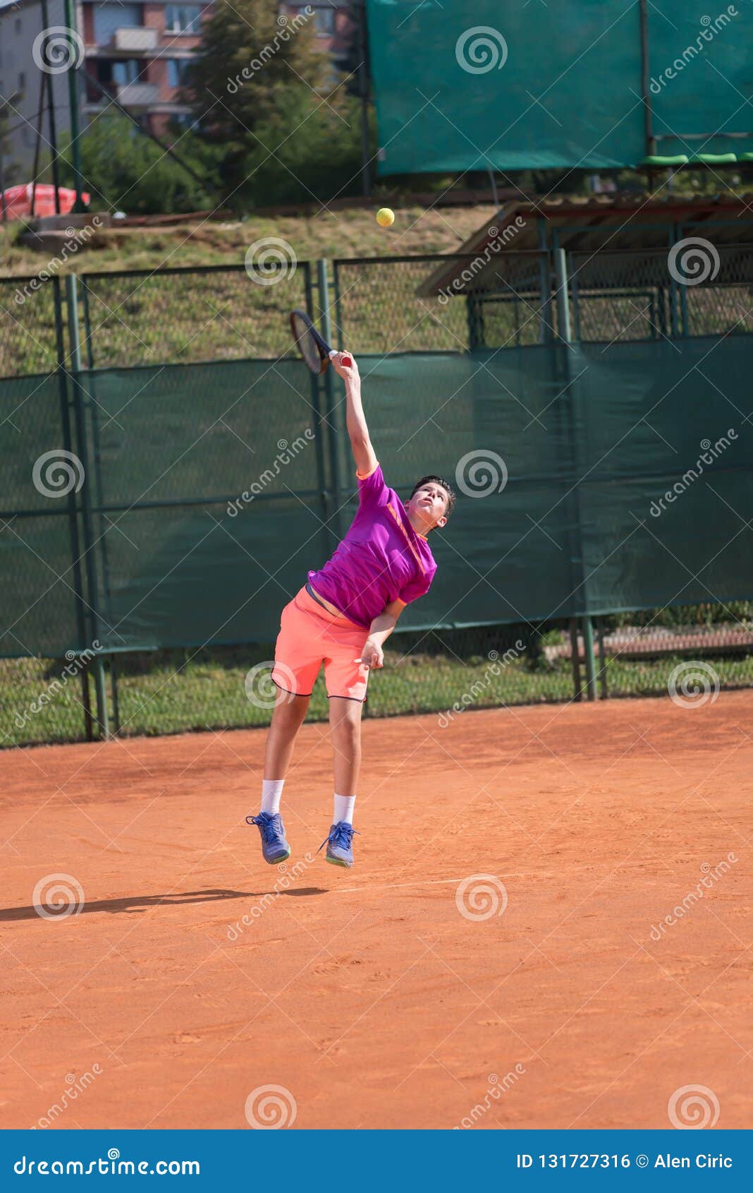 Young Tennis Player Serving the Ball with High Impact Stock Photo ...