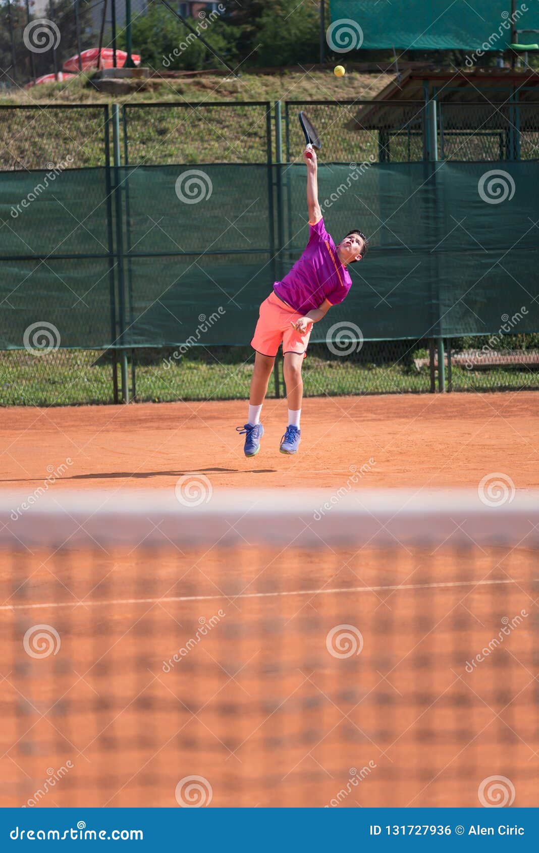 Young Tennis Player Serving the Ball with High Impact Stock Photo ...