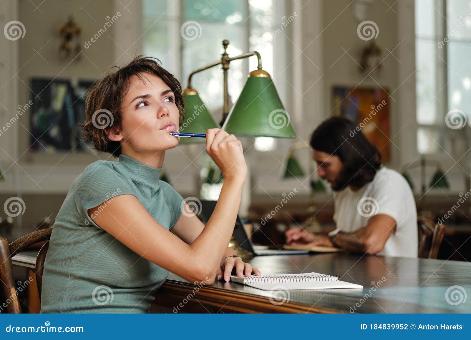Young Thoughtful Female Student Thinking about Study Project in Library ...