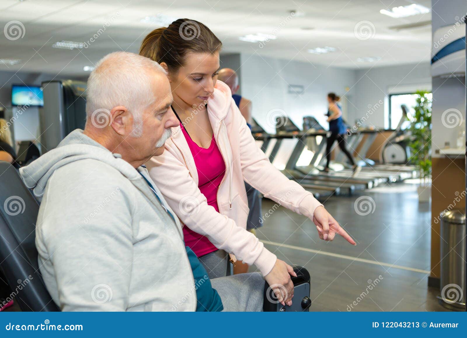 Young Trainer Helping Senior Worker Stock Image - Image of body ...