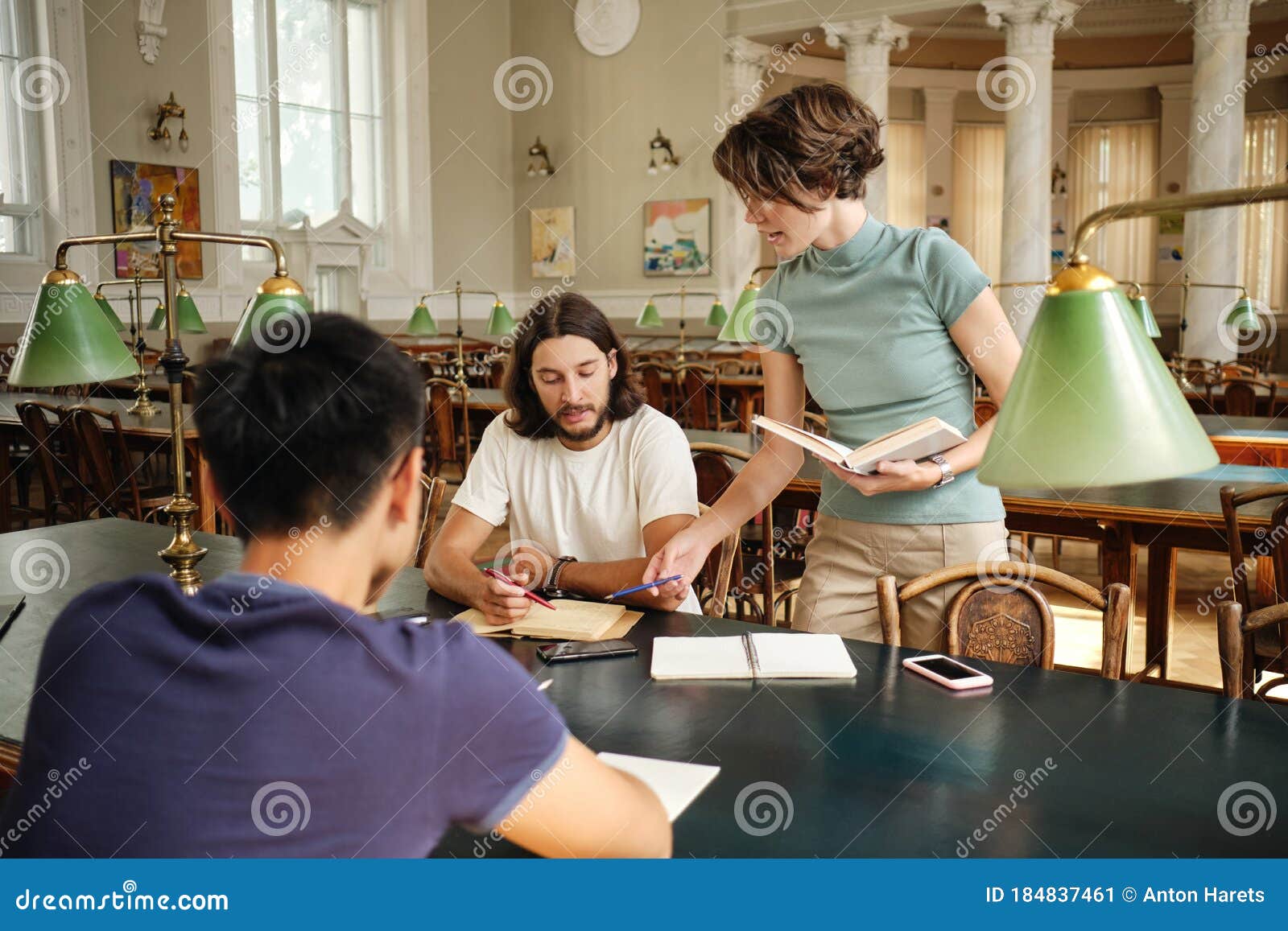 Young Tutor with Book Explaining To Students New Theme during Lesson in ...