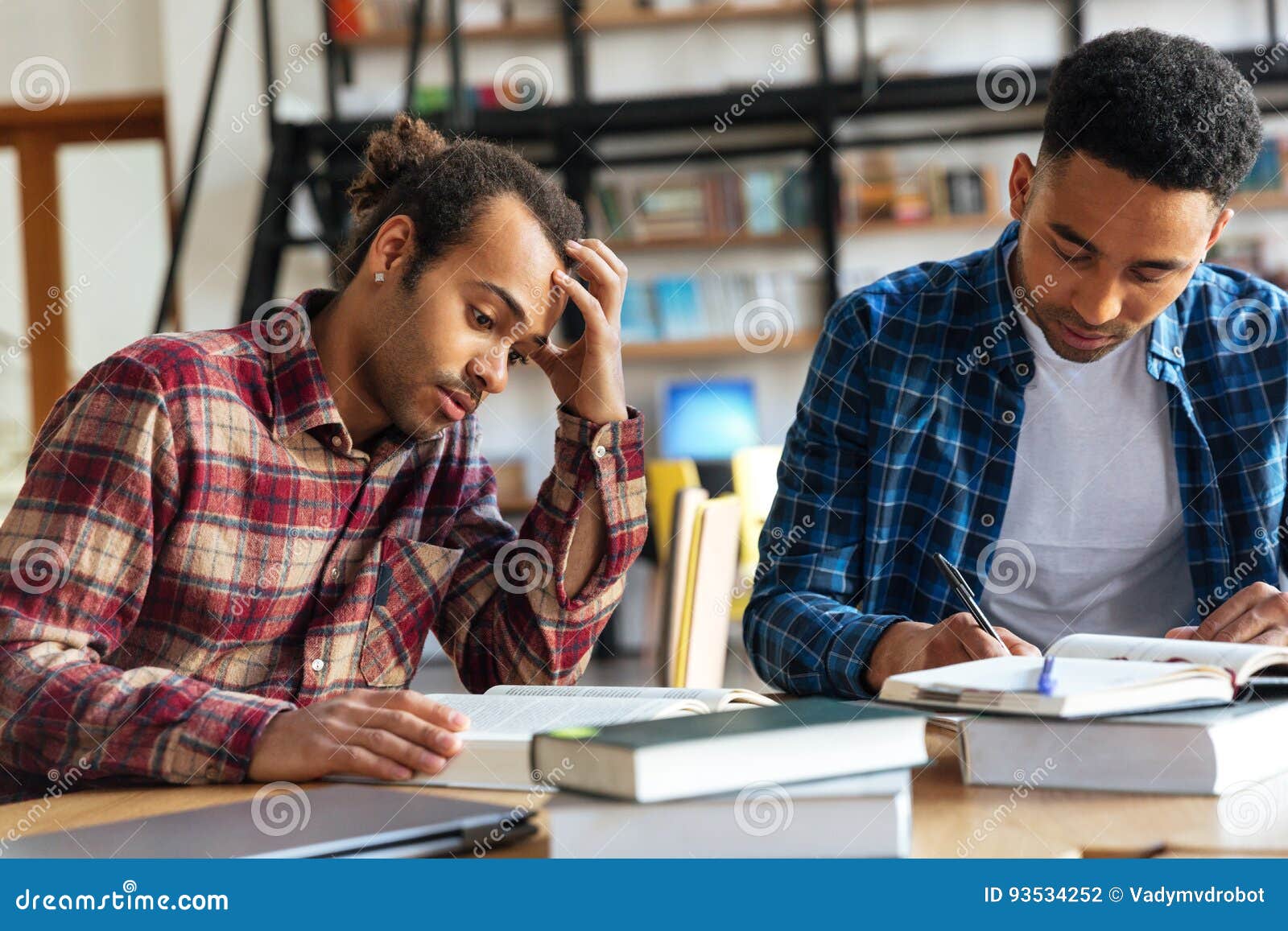 Young Two Men Students Sitting in Library Reading Books Stock Photo ...