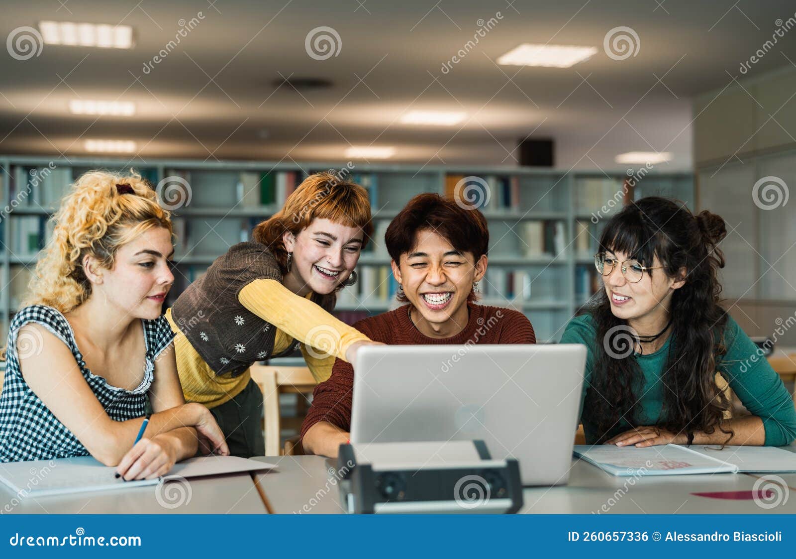 Young University Students Using Laptop and Studying with Books in ...