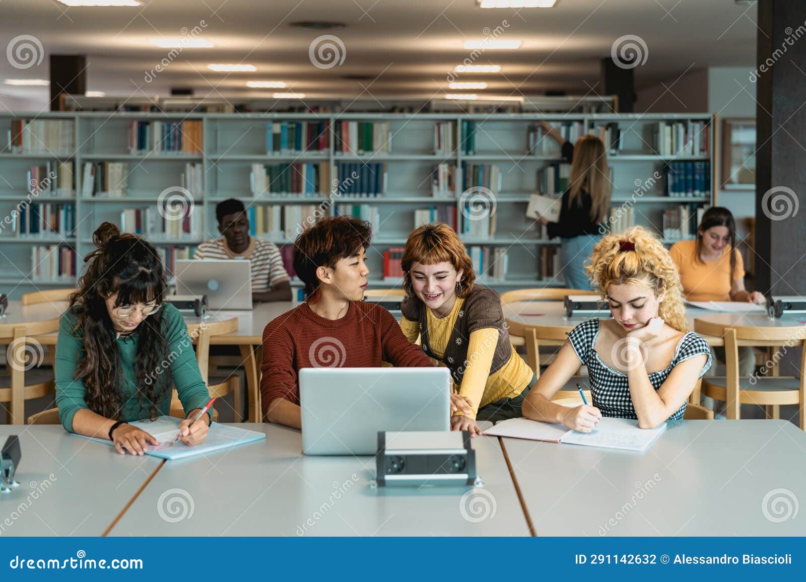 Young University Students Using Laptop and Studying with Books in ...