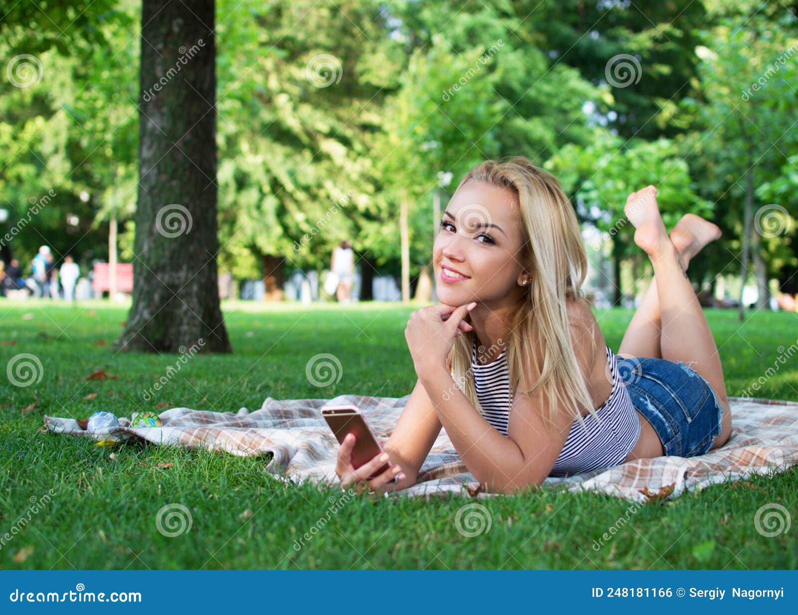 Young Very Beautiful Blonde Girl Is Lying On The Grass On A Sunny