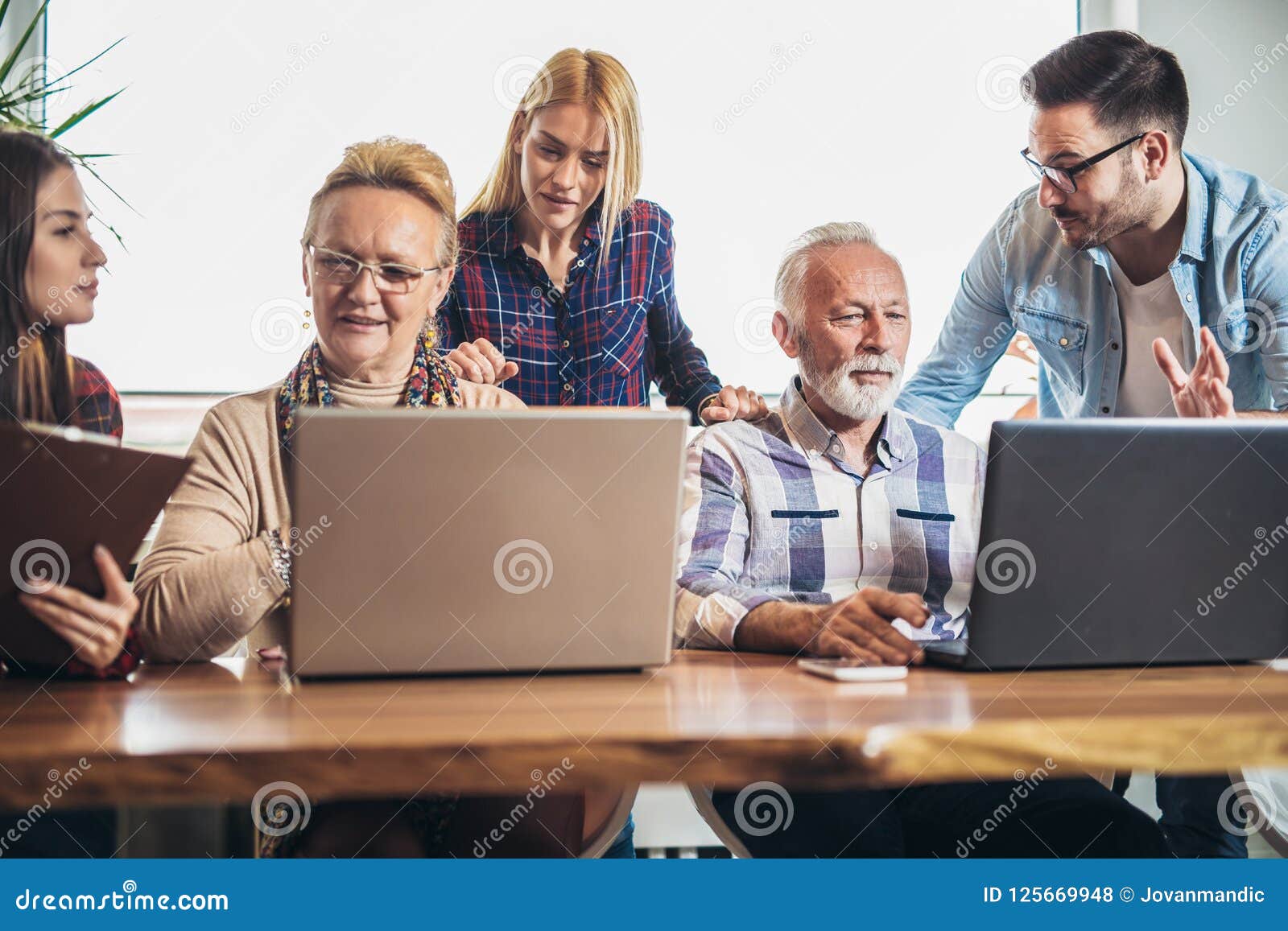 Young Volunteers Help Senior People on the Computer. Stock Photo ...