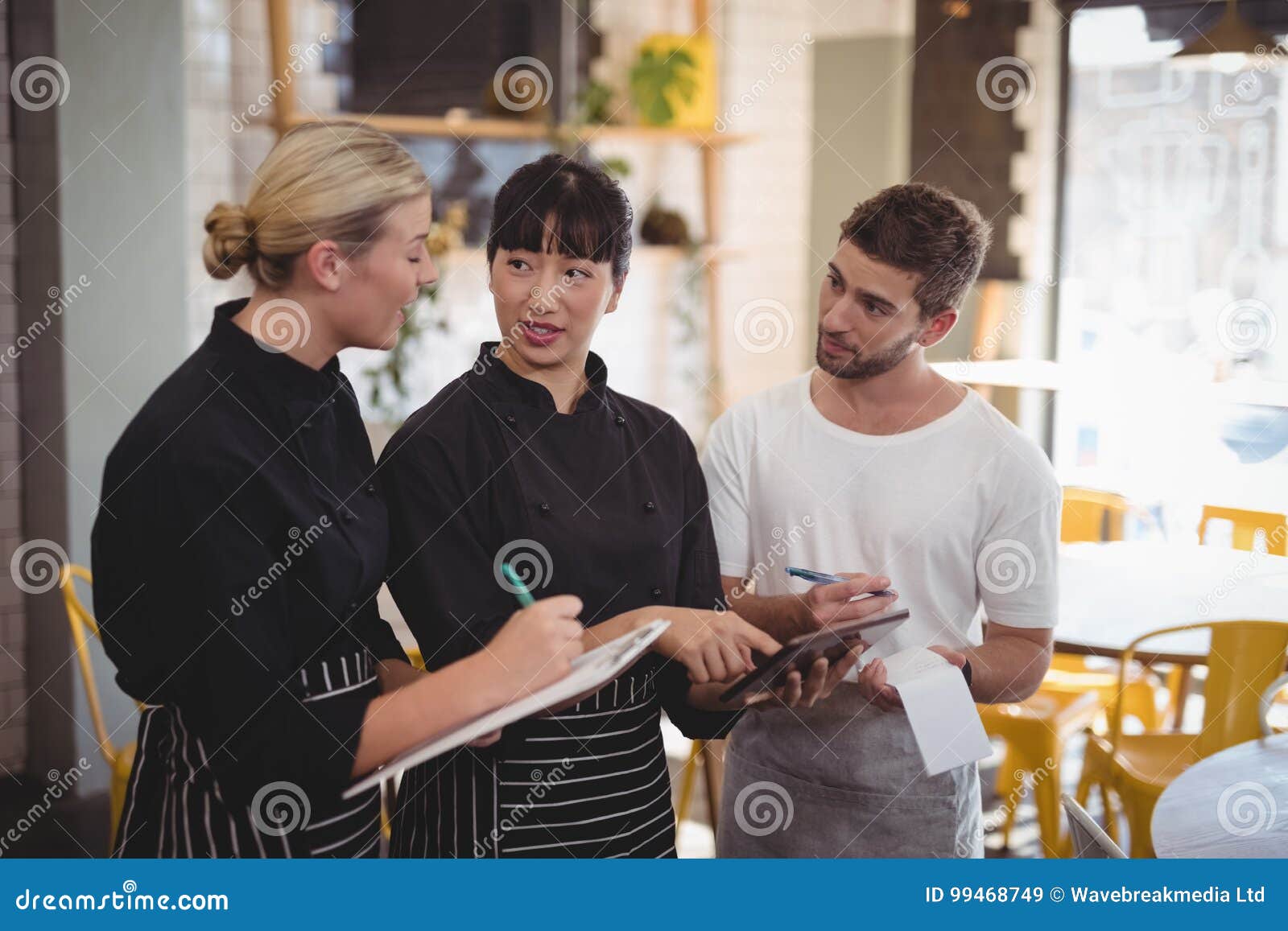 Young Wait Staff Discussing Over Tablet Computer at Coffee Shop Stock ...