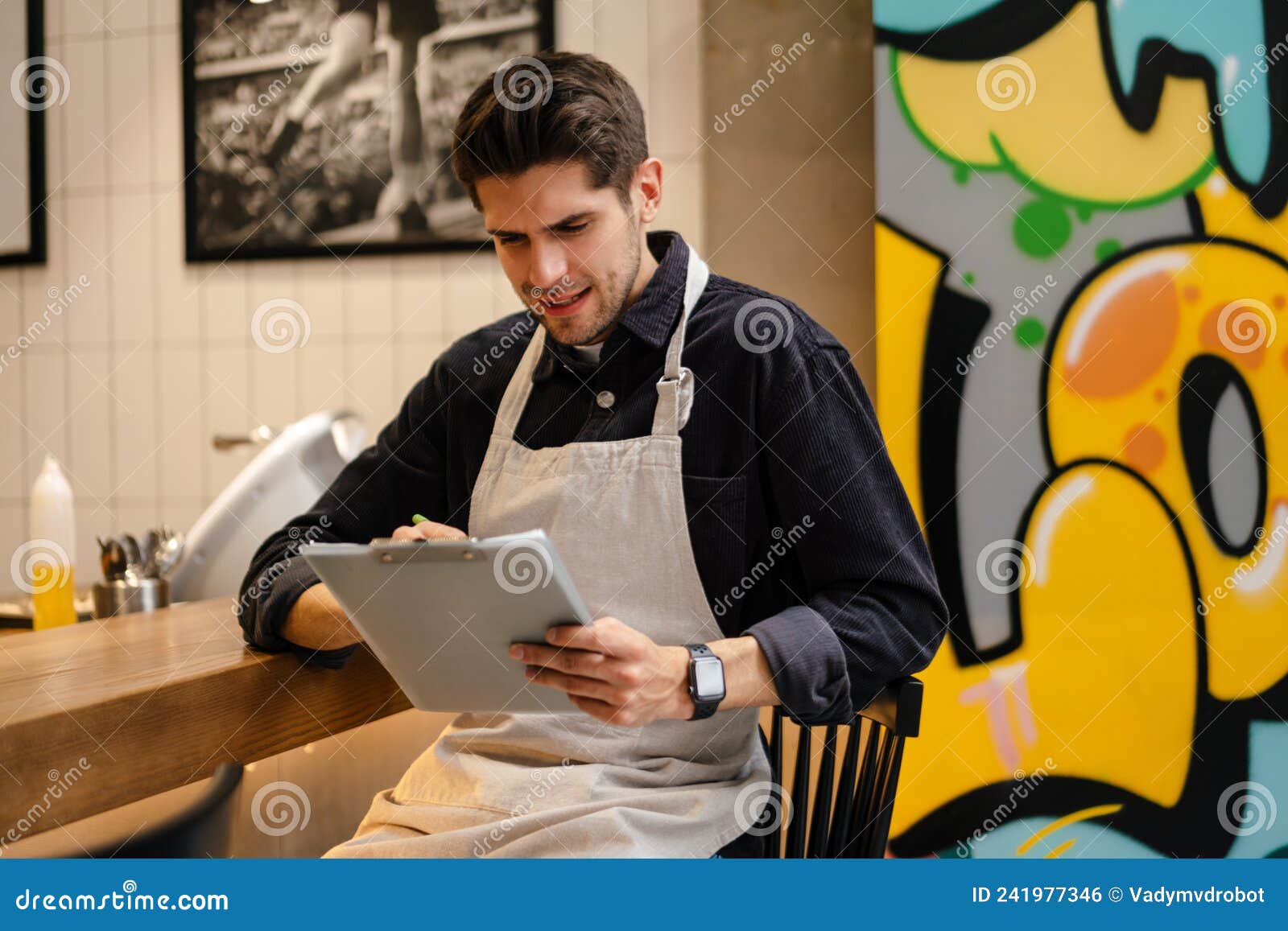 Young Waiter Checking the Quality of Goods Stock Photo - Image of write ...