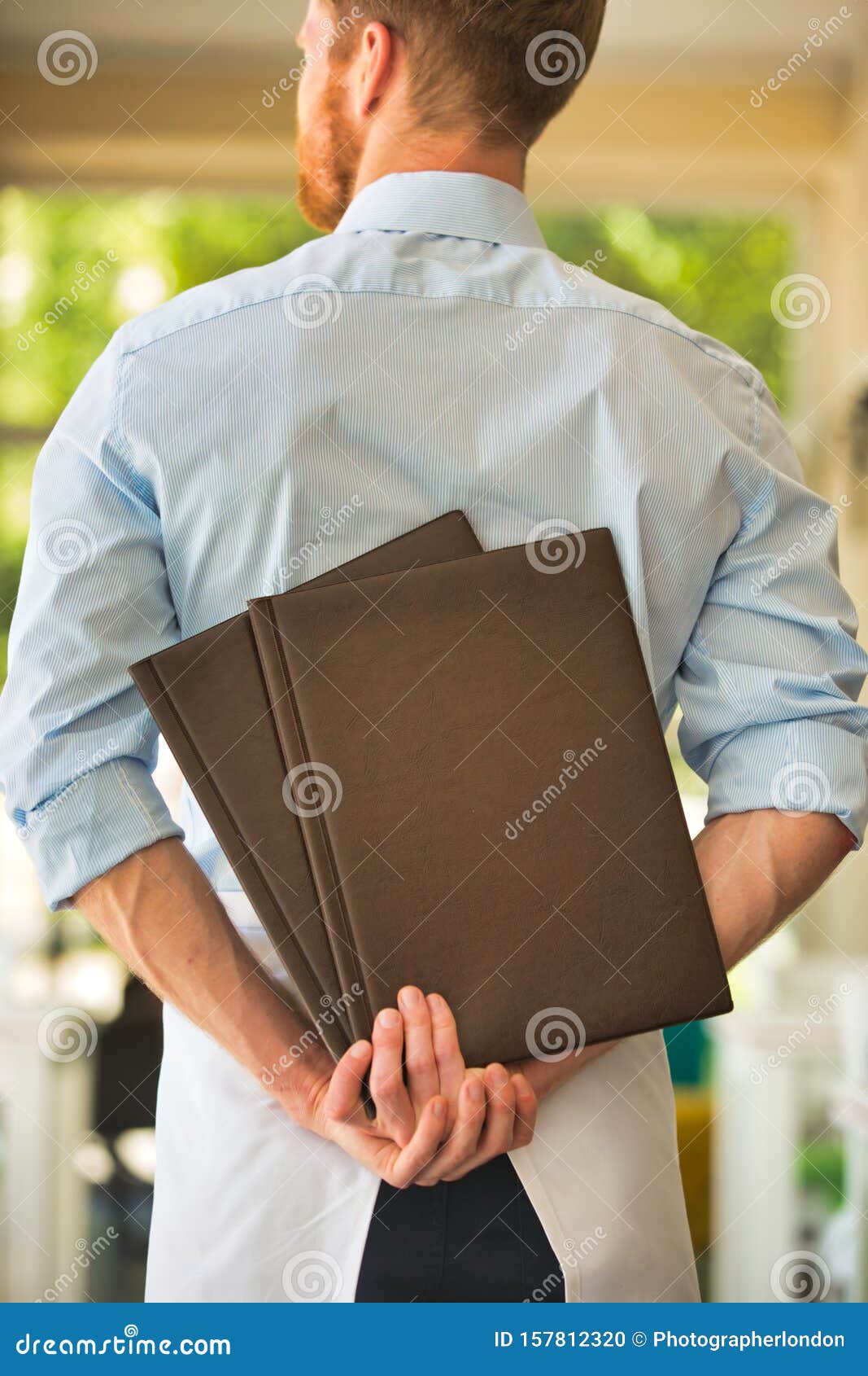 Rear View of Young Waiter Holding Menus while Standing at Restaurant ...