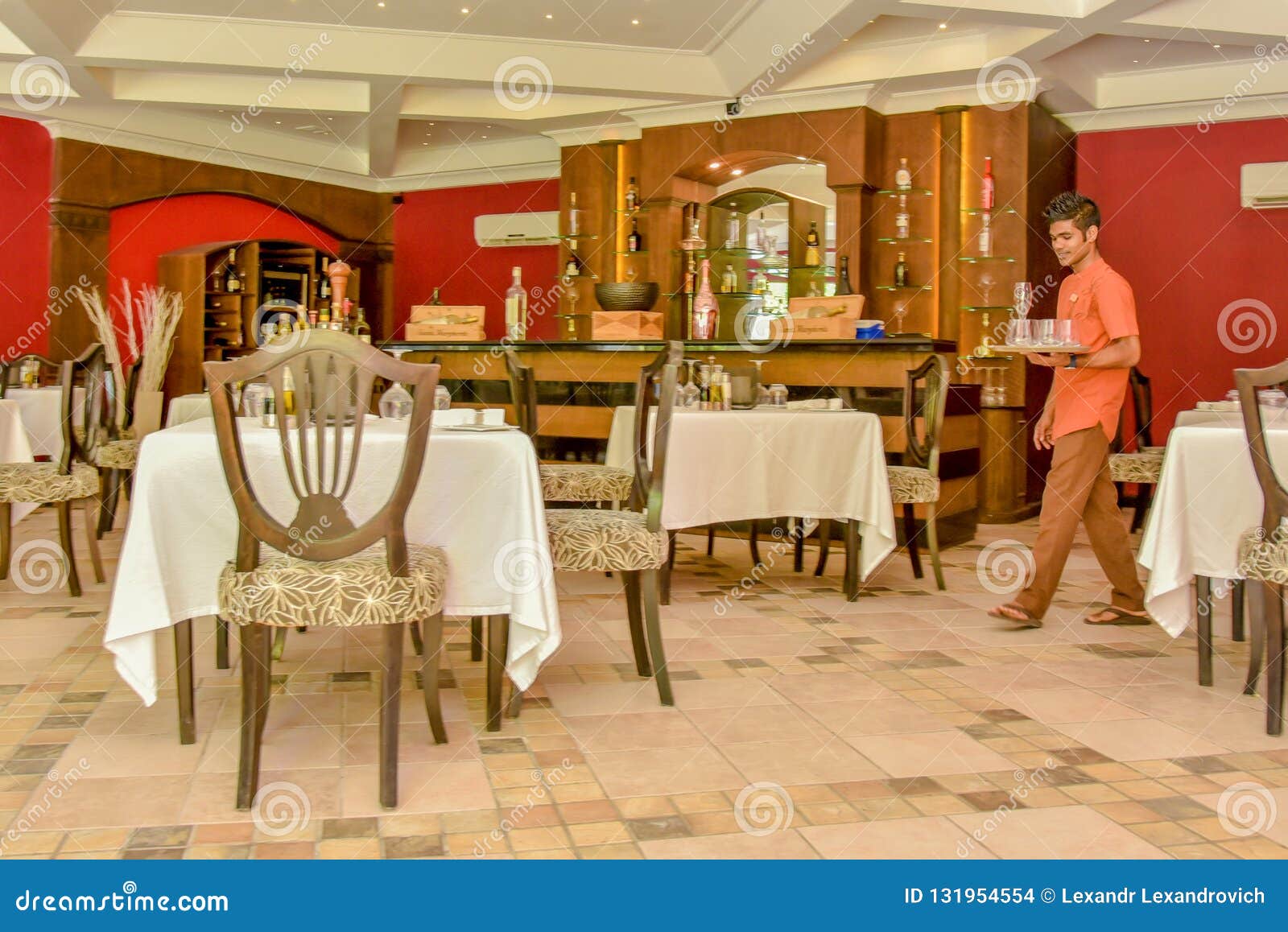 Young Waiter in the Uniform Walking Towards Table with a Tray Editorial ...