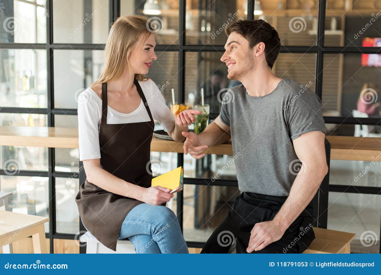 Young Waiter and Waitress Having Conversation during Break at Work ...
