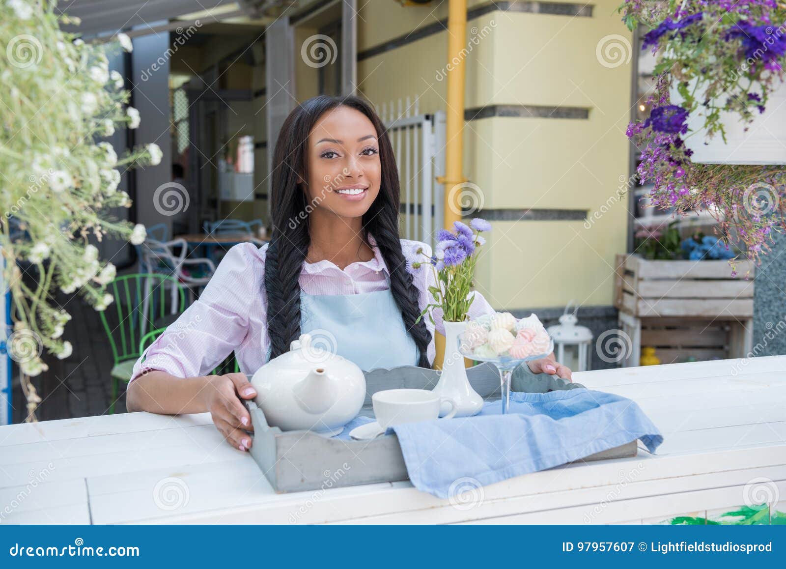 Young Waitress Serving Table with Tea Set and Smiling at Camera Stock ...