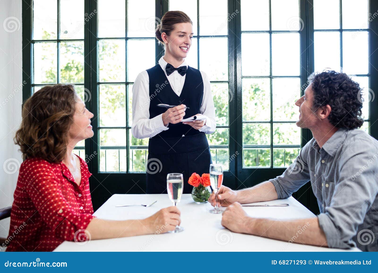 Young Waitress Taking an Order from a Couple Stock Image - Image of ...