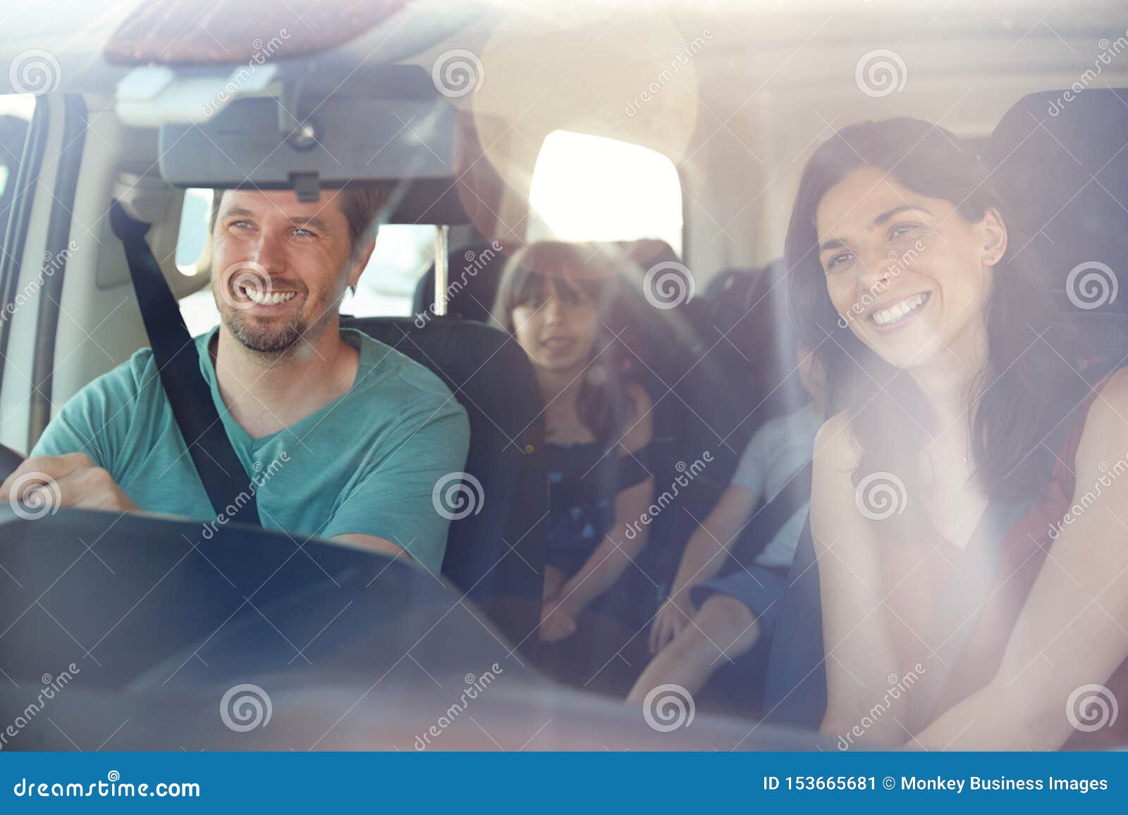 Young White Family of Four Setting Off on a Journey in Their Car, Seen ... Young White Family of Four Setting Off on a Journey in Their Car, Seen ...