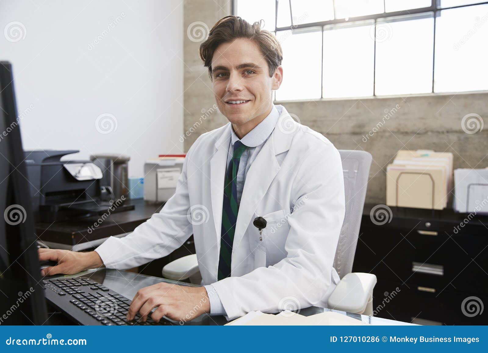 Young White Male Doctor Using Computer Smiling To Camera Stock Photo ...