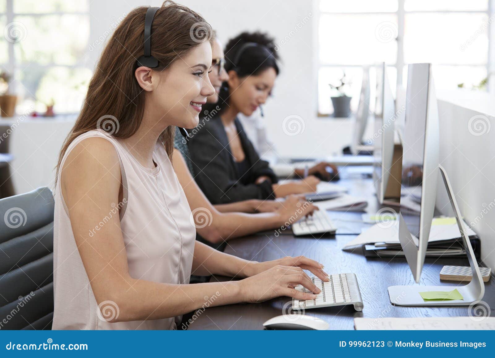 Young White Woman Working at Computer in Office with Headset Stock ...