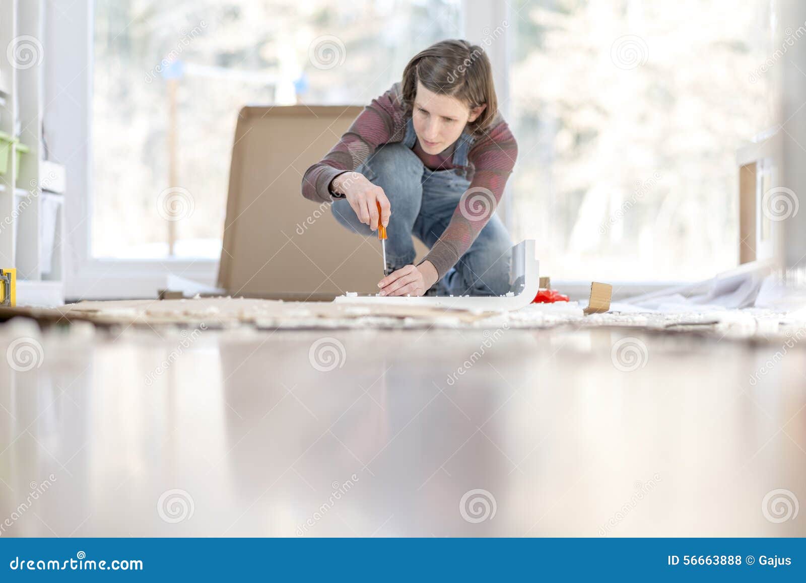 Young Woman Assembling a DIY Furniture at Home Kneeling on the F Stock ... Young Woman Assembling a DIY Furniture at Home Kneeling on the F Stock ...
