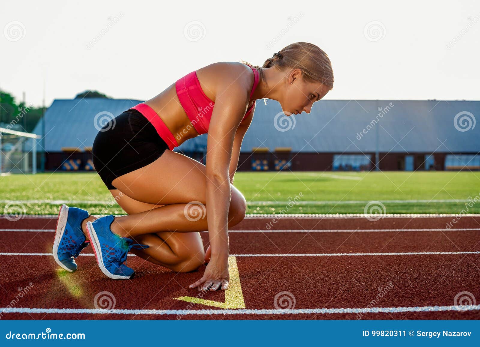 Young Woman Athlete At Starting Position Ready To Start A Race On