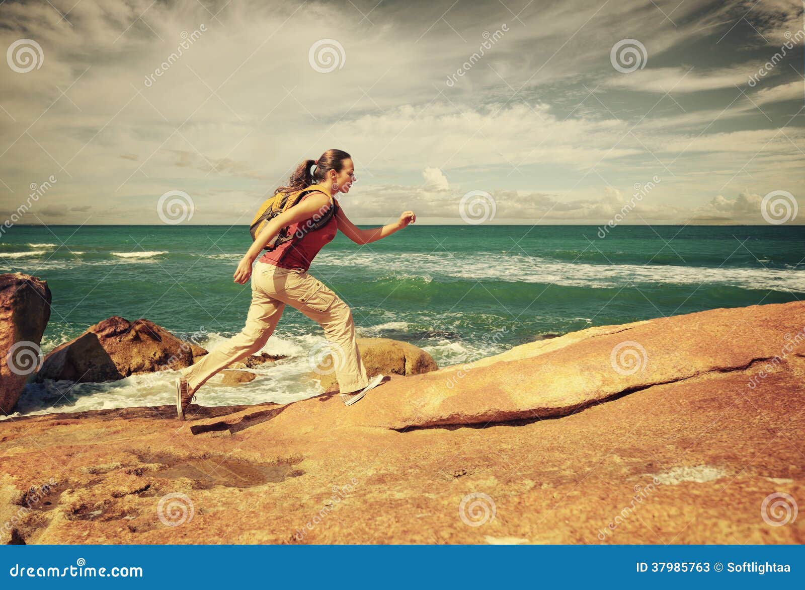 Young Woman with a Backpack Runs on Coastal Rocks Stock Image - Image ...