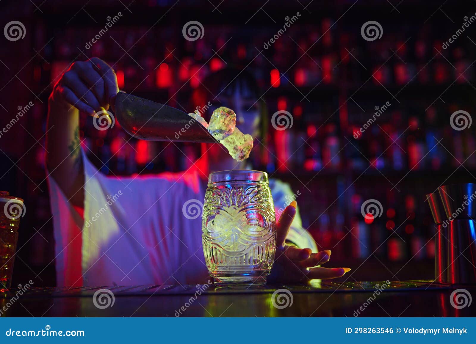 Young Woman Bartender Putting Ice Cubes Into Glass Making Delicious