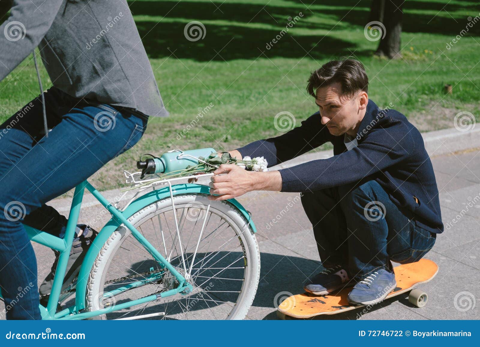 Young Woman on Bicycle Pulling a Man on a Skateboard Stock Photo ...