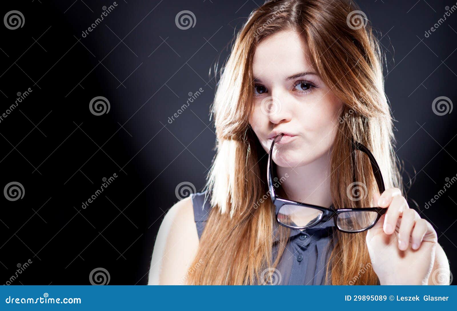 Young Woman Biting a Nerd Glasses with Interested Look Stock Image ...