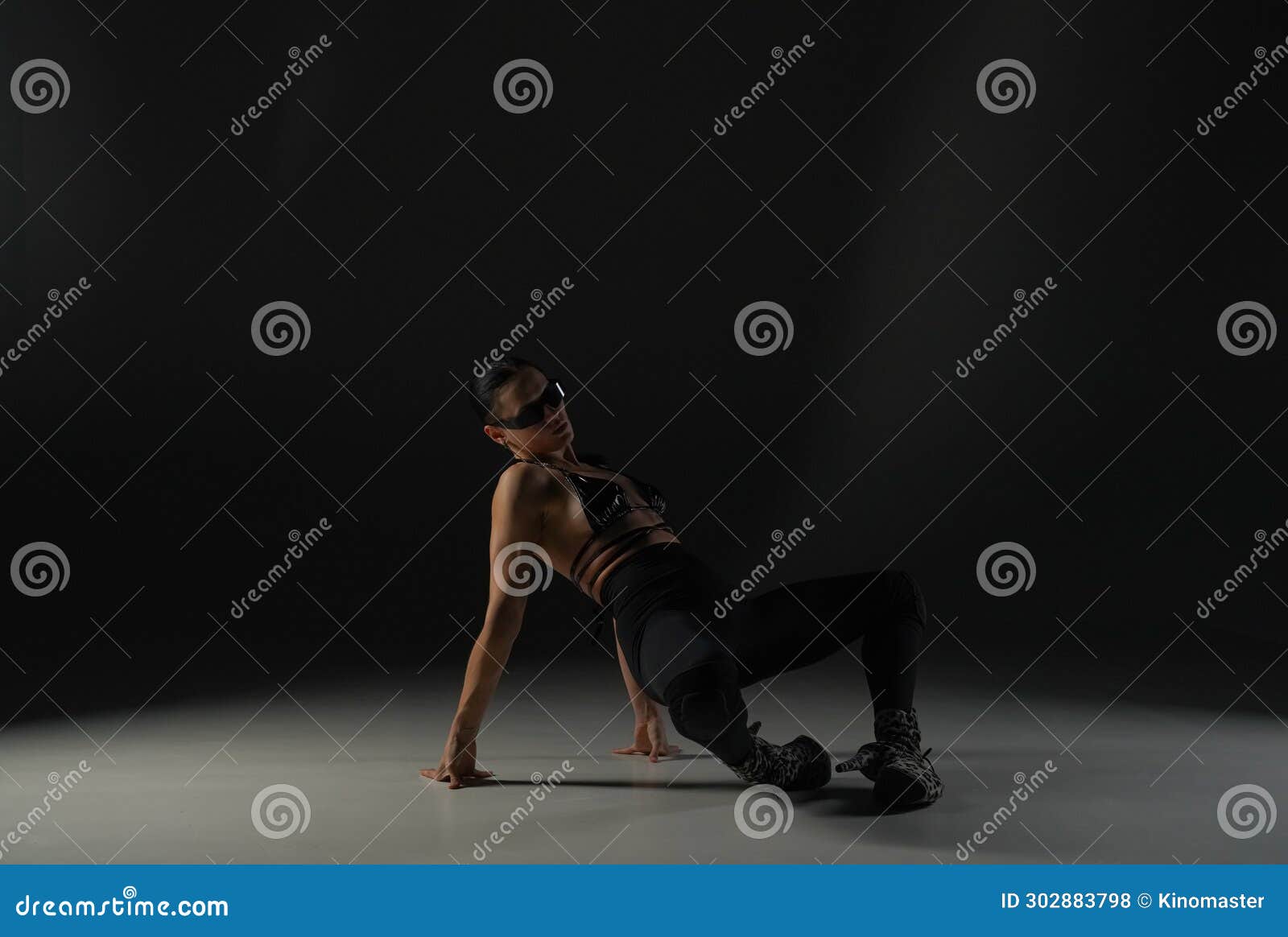Young Woman in Black Open Clothes Poses on Black Background of Backlit ...