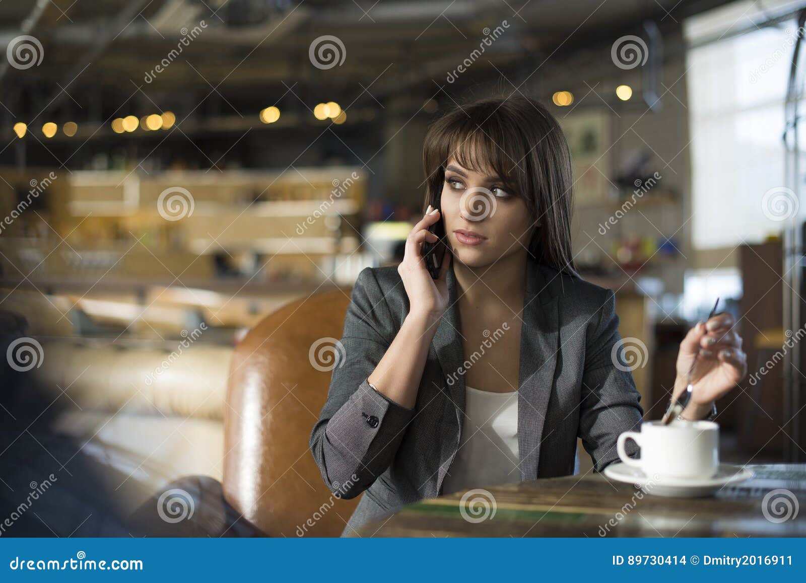 Young Woman at Cafe Drinking Coffee and Talking on the Mobile Phone ...