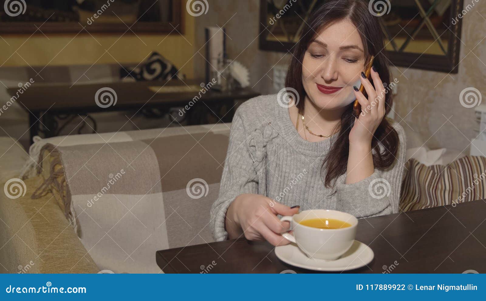 Young Woman in a Cafe Drinking Tea and Talking on the Phone Stock Photo ...