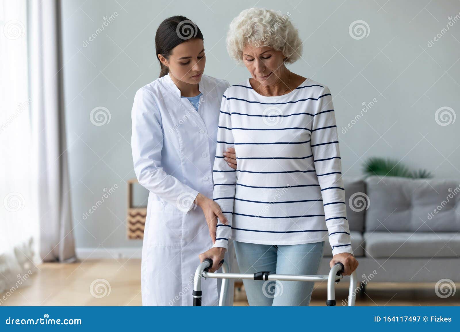 Young Woman Caregiver Helping Disabled Old Grandma Patient Using Walker