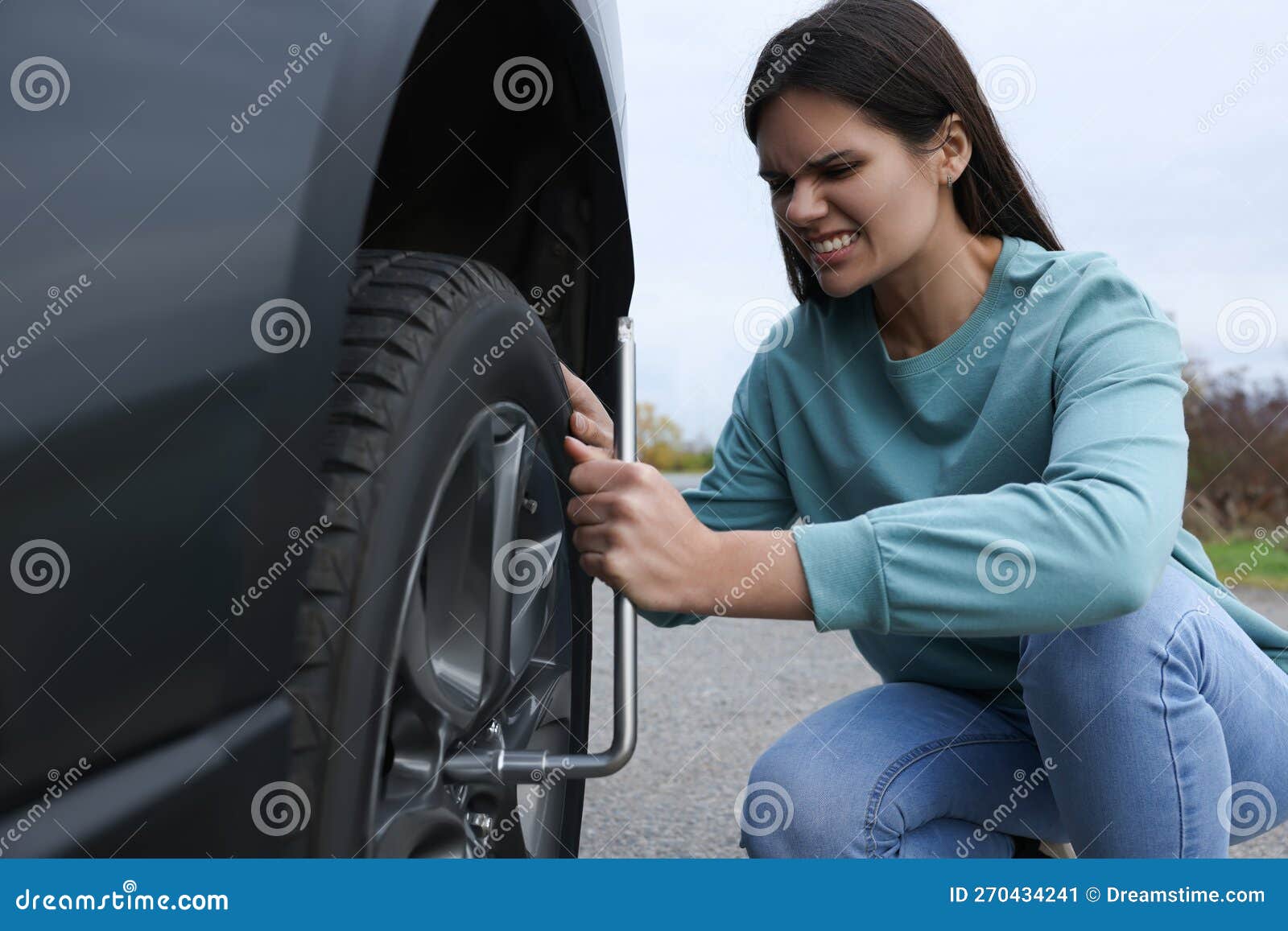 Young Woman Changing Tire of Car Outdoors Stock Image - Image of female ...